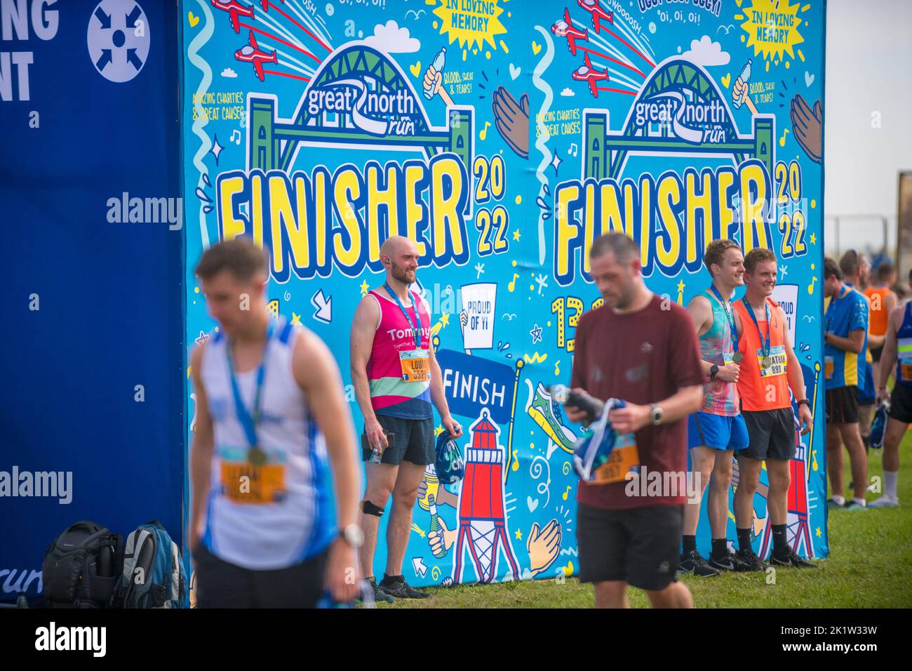 Competitors standing in front of the large finishers display having ...