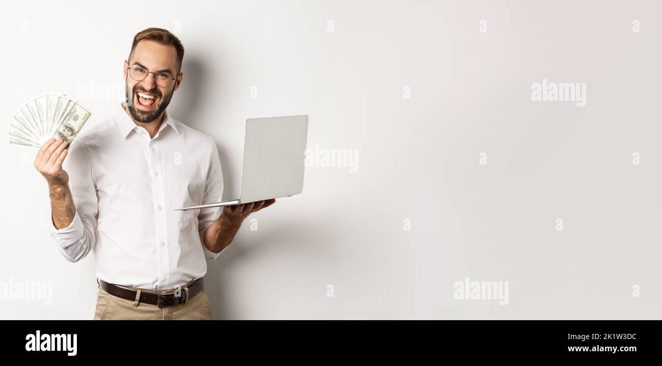 Business and e-commerce. Excited businessman holding money dollars and ...