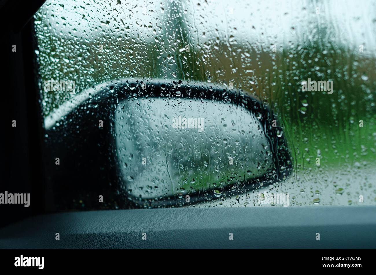 driving car on road in the rain with raindrop over the wind shield ...