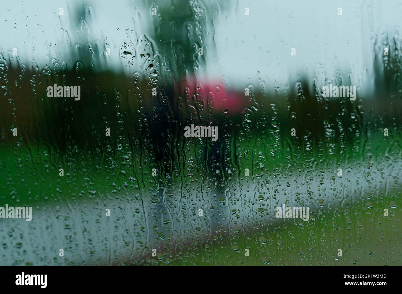 driving car on road in the rain with raindrop over the wind shield ...