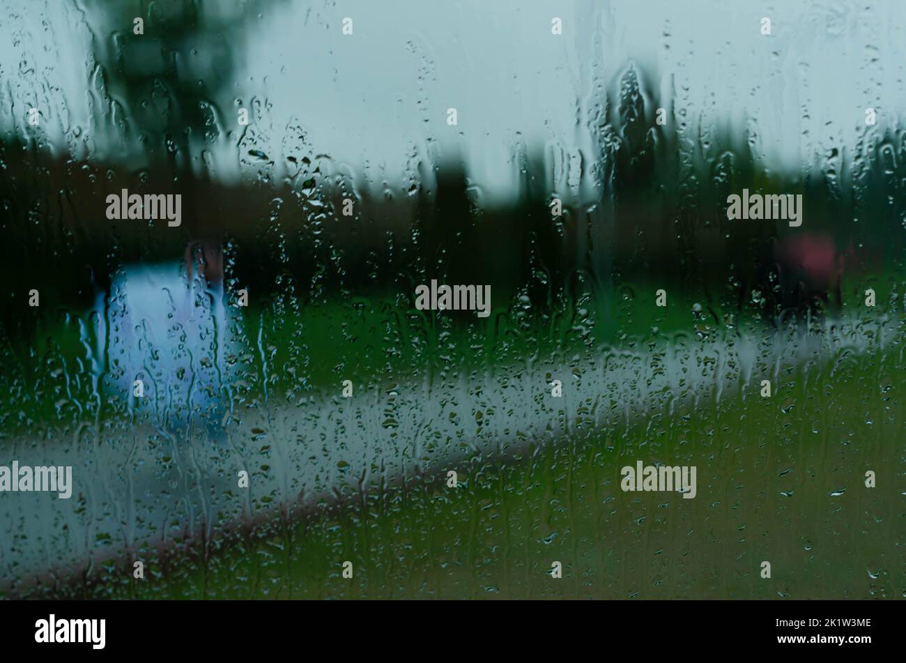driving car on road in the rain with raindrop over the wind shield ...