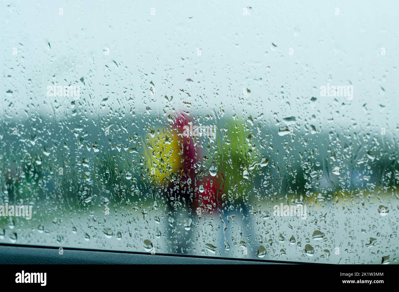 driving car on road in the rain with raindrop over the wind shield ...