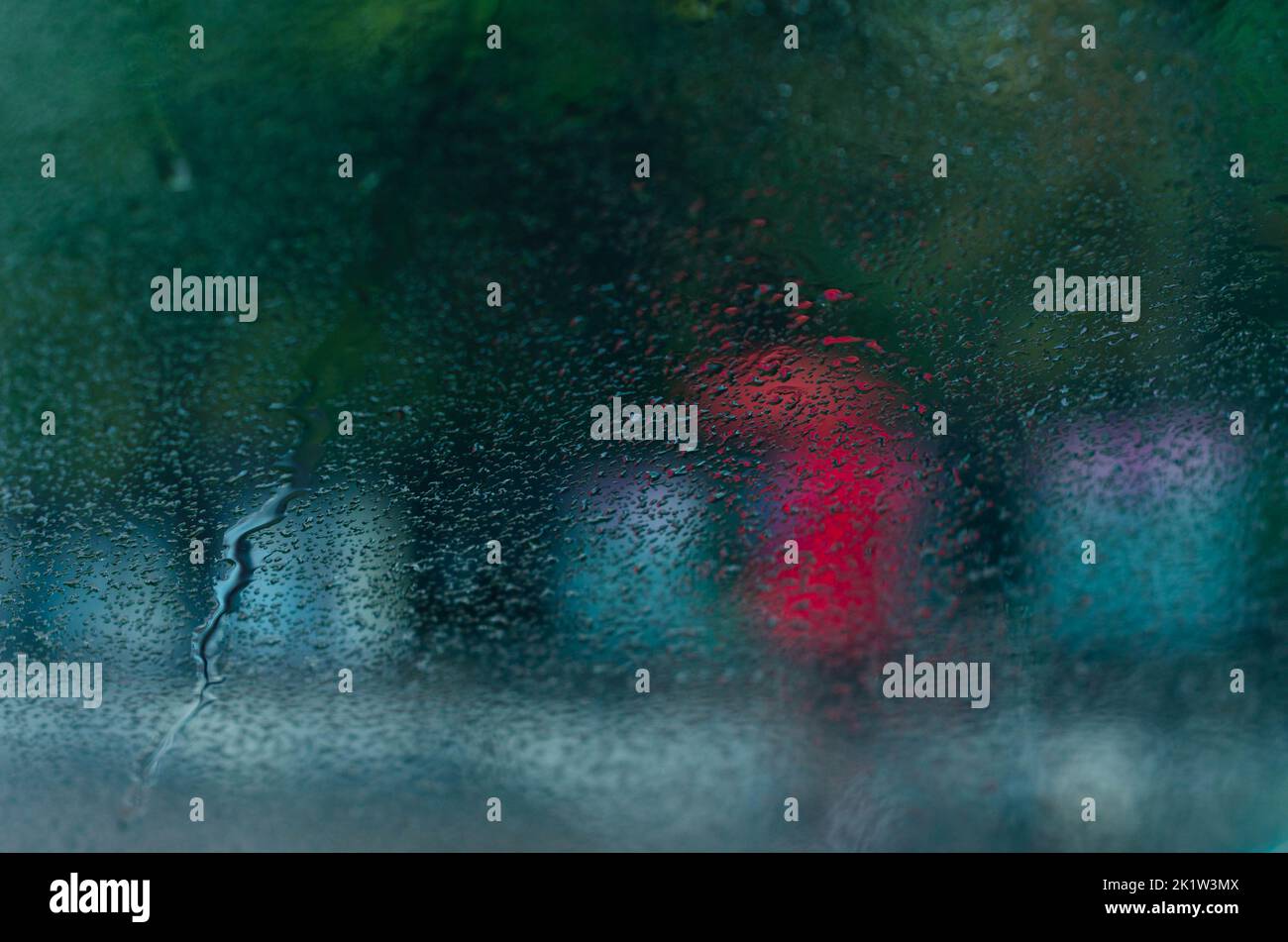 driving car on road in the rain with raindrop over the wind shield ...