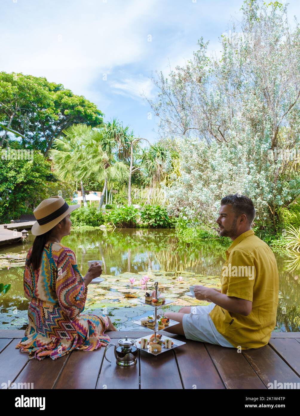 Afternoon tea at a water pond, high tea in a tropical garden in ...