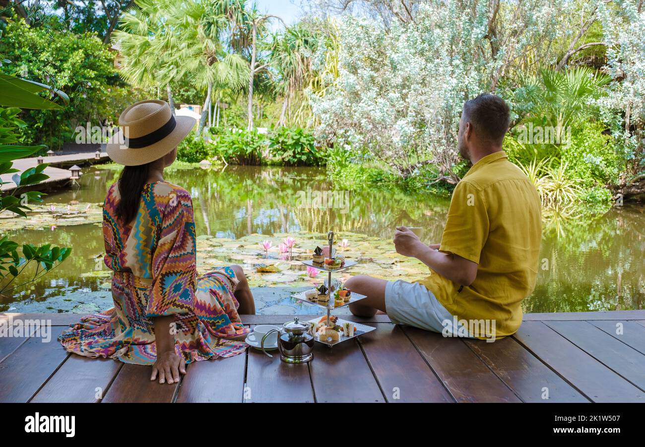 Afternoon tea at a water pond, high tea in a tropical garden in ...
