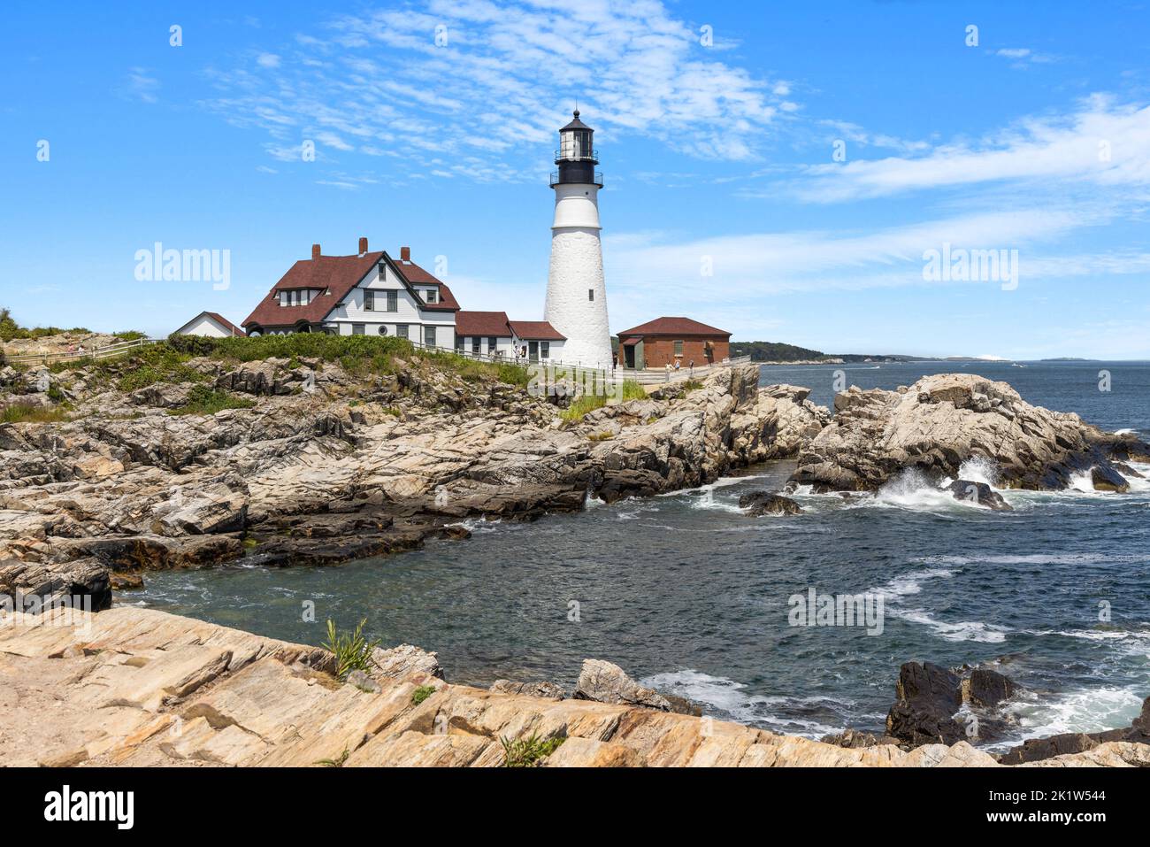 The Portland lighthouse with a house by the sea at Fort Williams Park ...