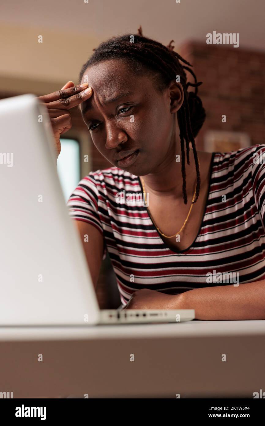 Stressed tired student having migraine, looking at laptop screen ...