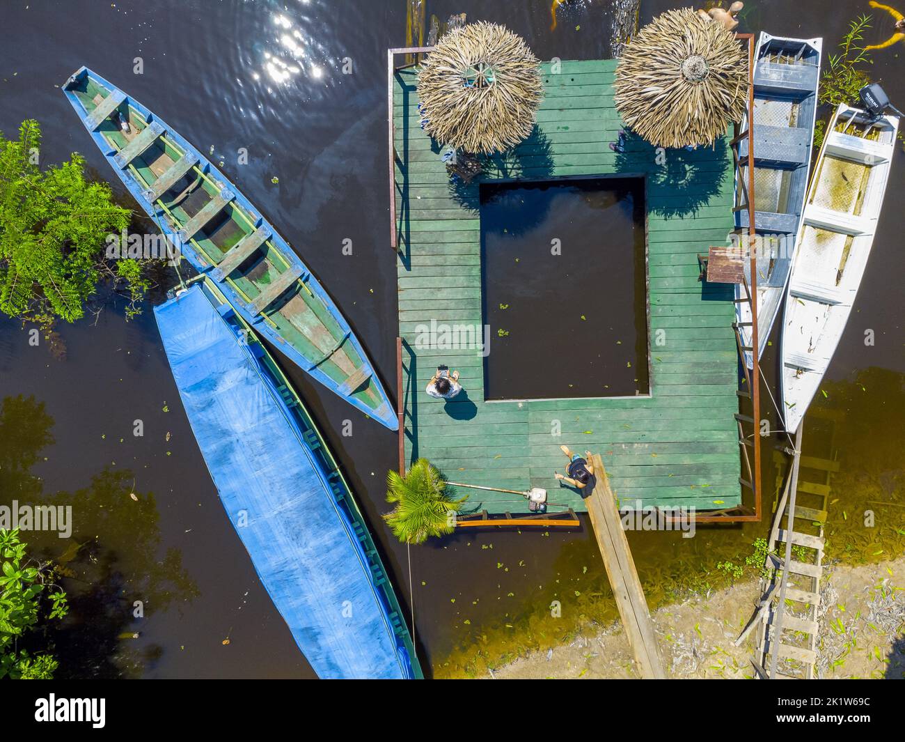 Aerial top view of a small wooden pier and some conoes in the amazon ...