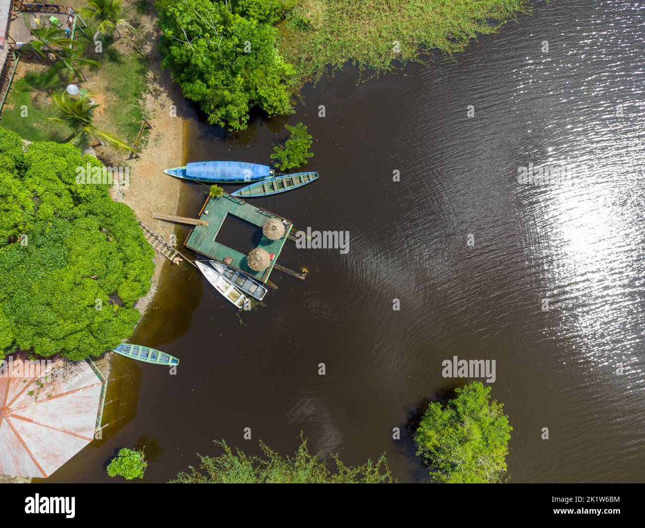 Aerial top view of a small wooden pier and some conoes in the amazon ...
