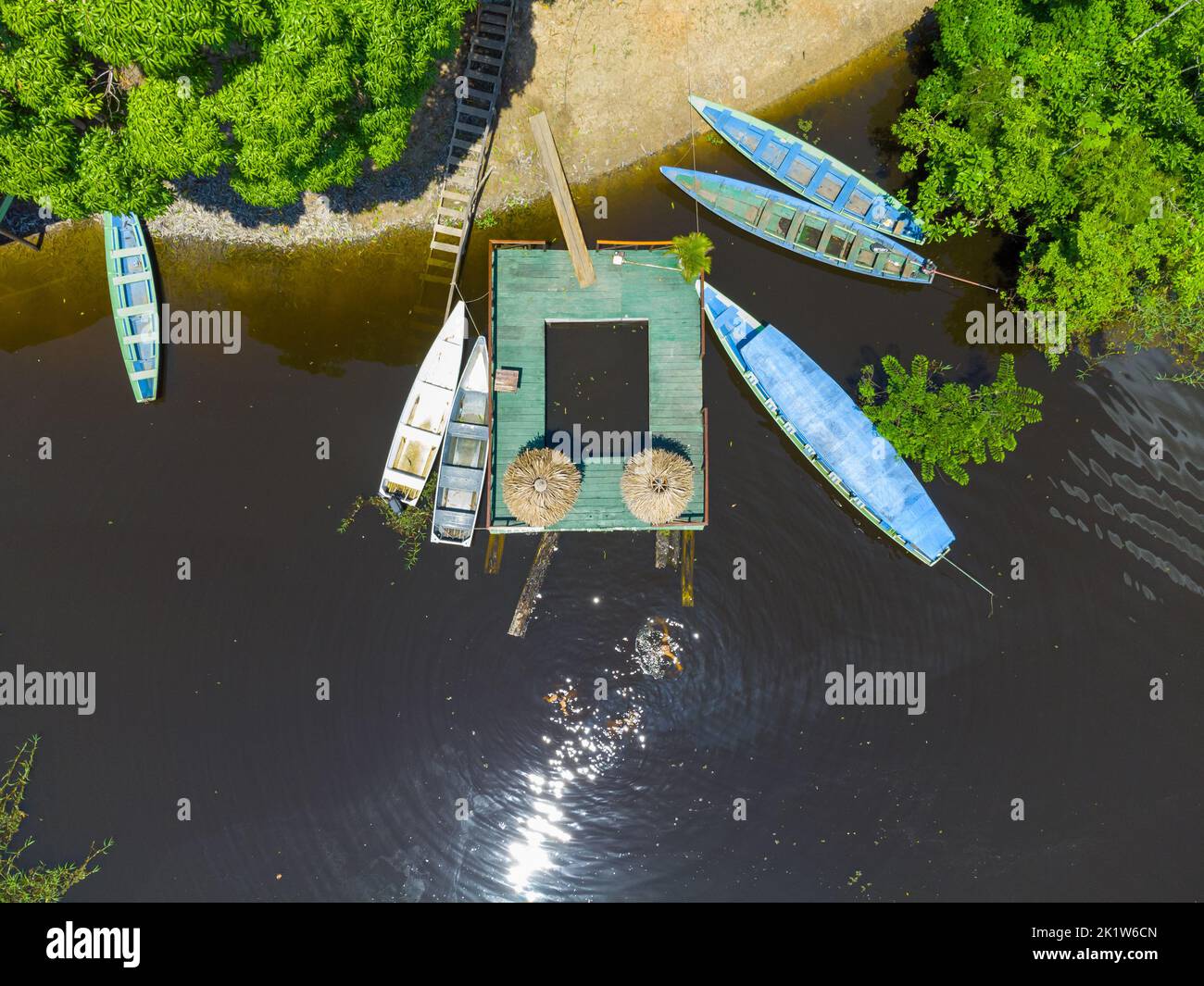 Aerial top view of a small wooden pier and some conoes in the amazon ...