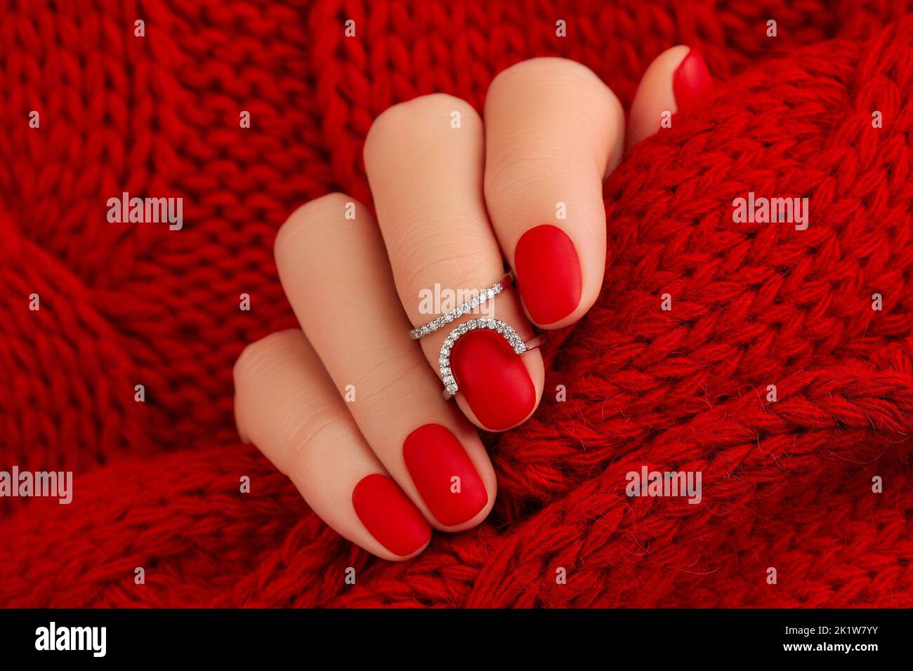 Female hand with manicure holding fabric. Red matt nail design Stock ...