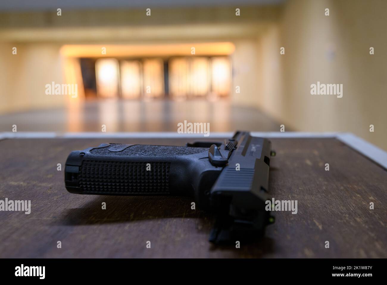 A Heckler and Koch P8 pistol lays in front of targets as U.S. Soldiers ...