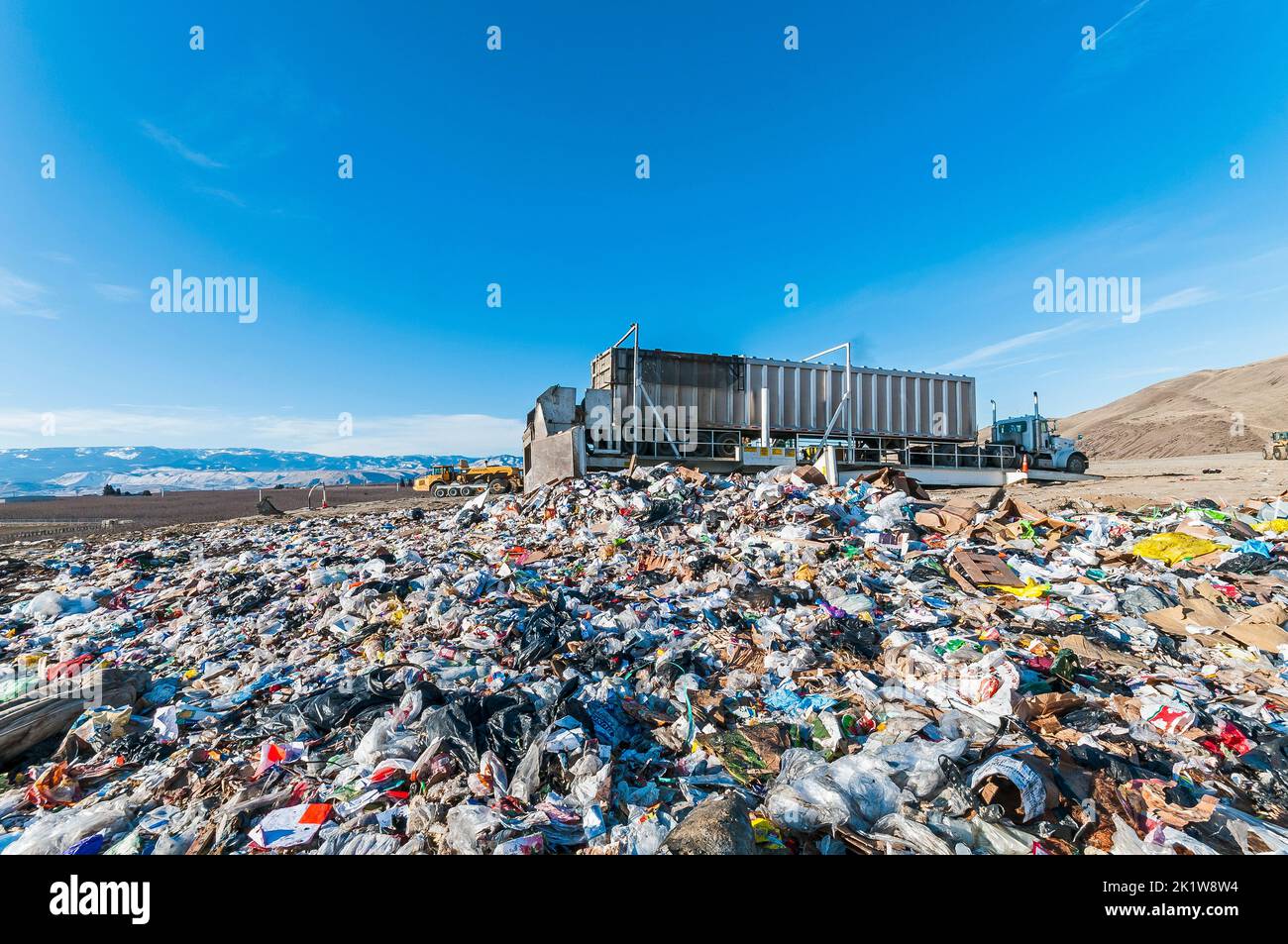 A semitrailer is positioned in a landfill tipper with truck tractor in ...