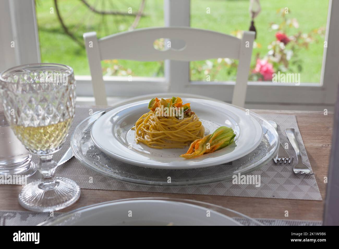 lunch set table in a bay window with zucchini floers spaghetti Stock ...