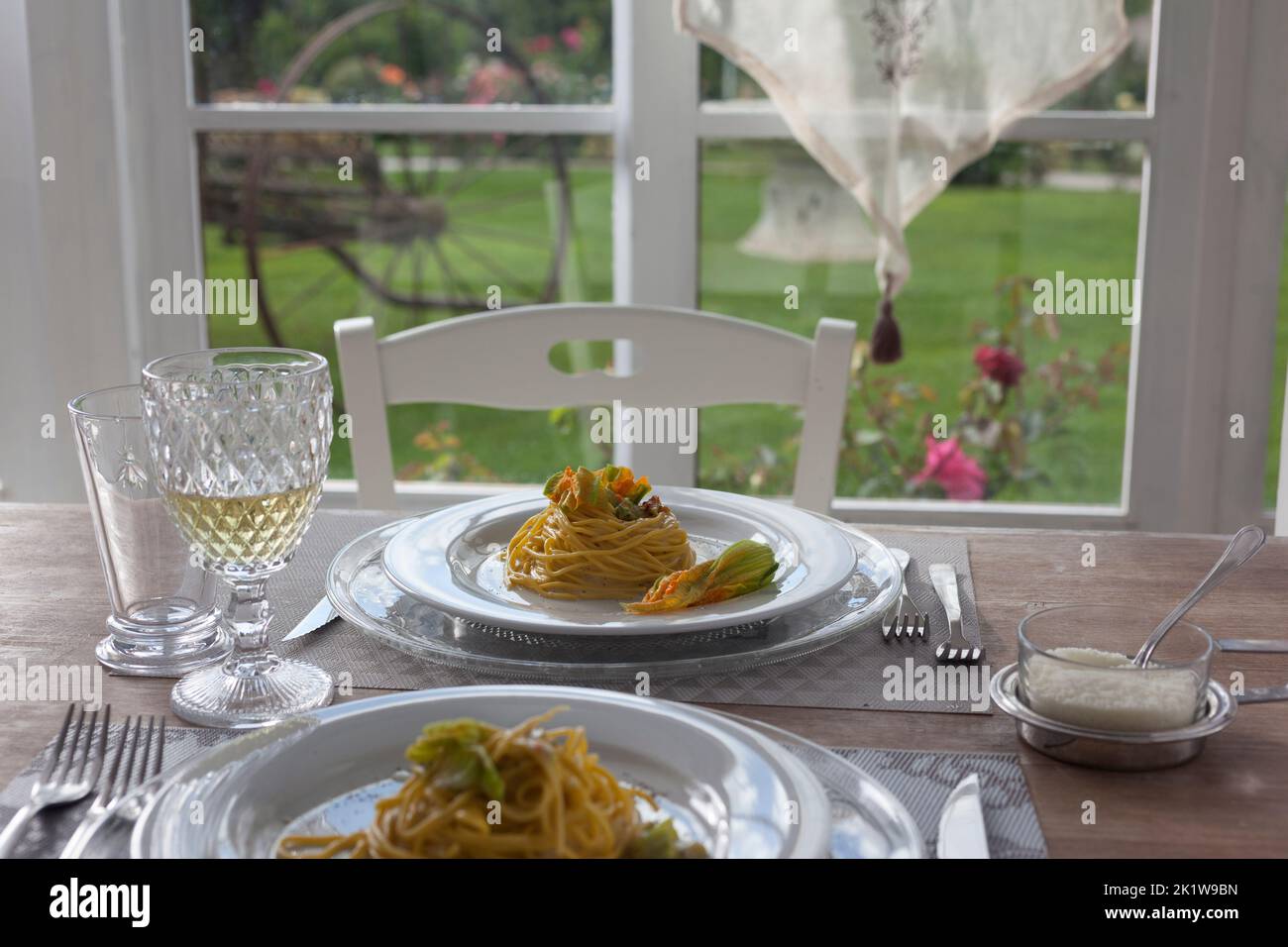 lunch set table in a bay window with zucchini floers spaghetti Stock ...