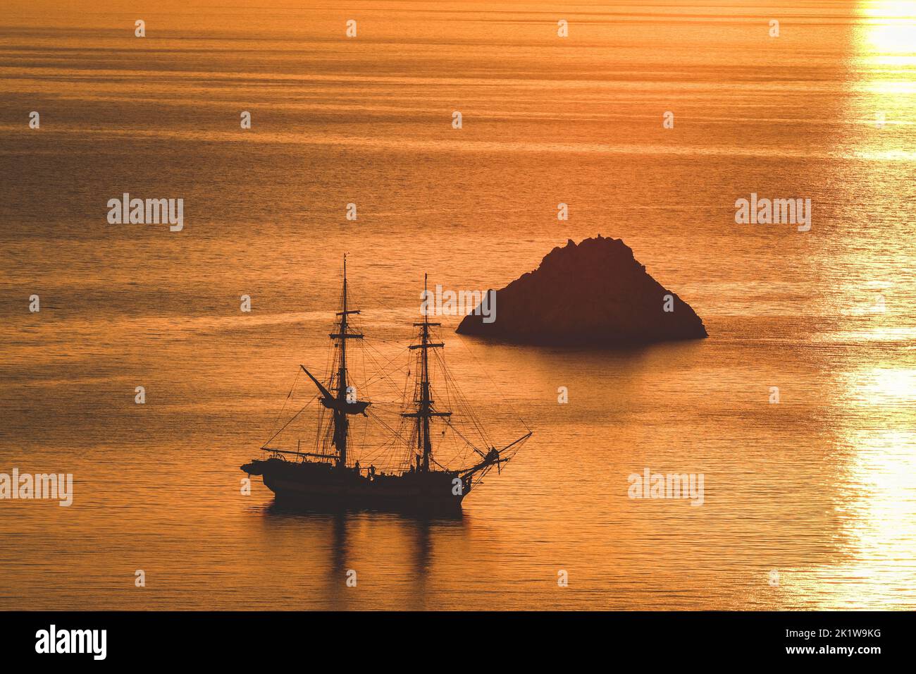 A silhouette of a ship sailing in the sea at sunset Stock Photo - Alamy