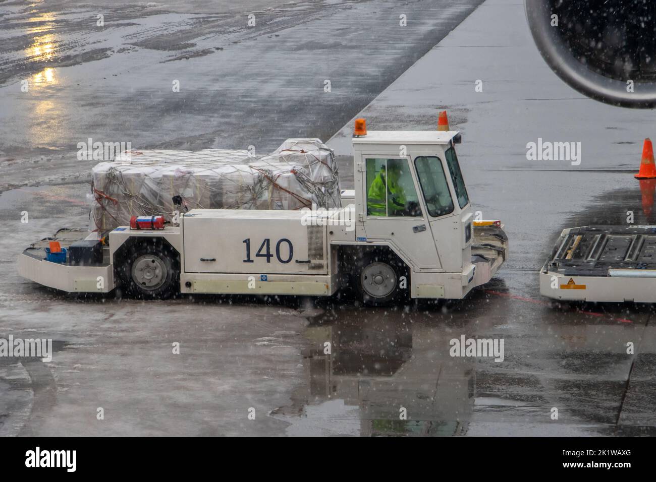 A vehicle loaded with air cargo is driving on a snowy airport Stock ...