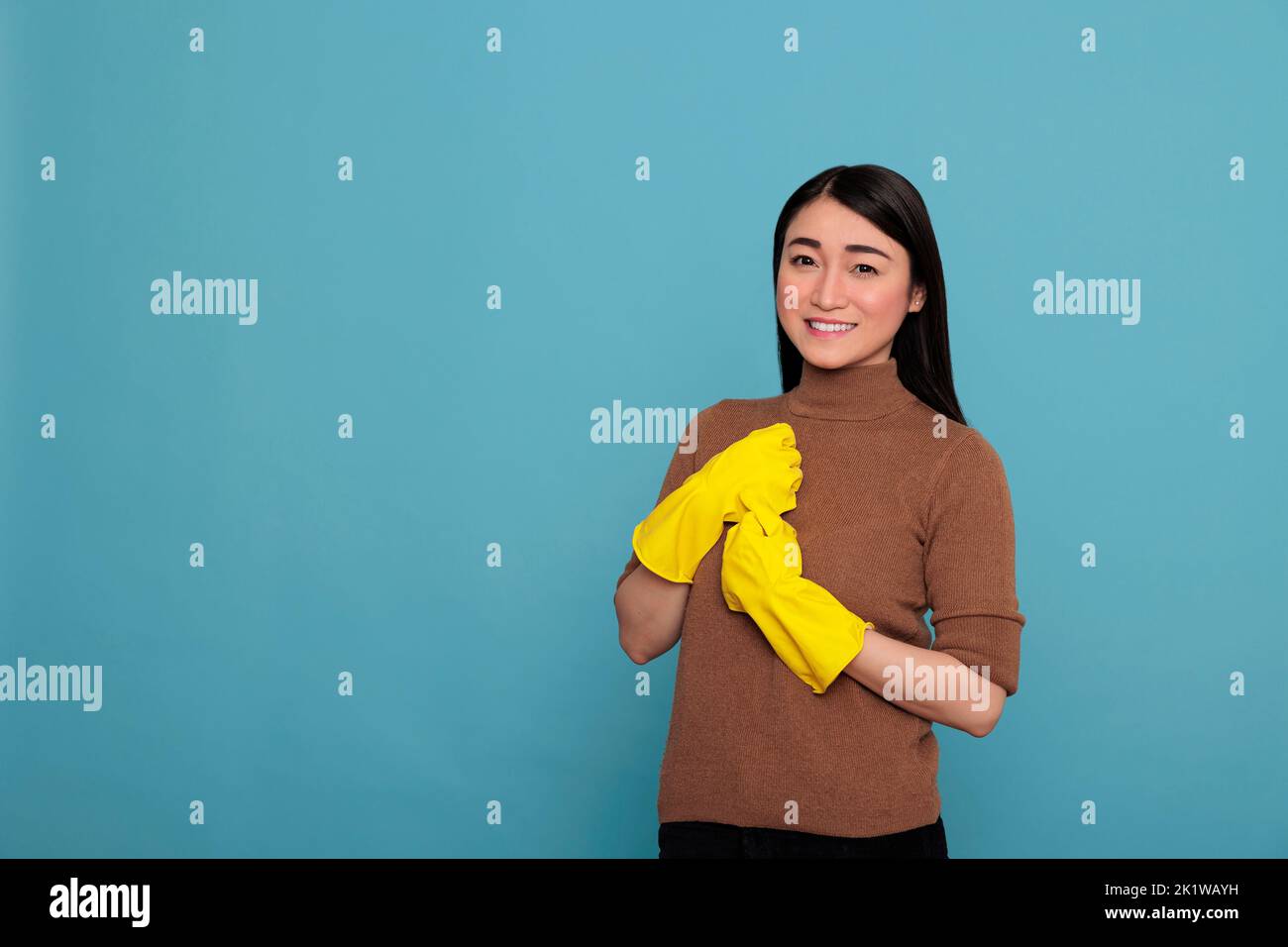 Glade happy asian maid holding hand from chores wearing rubber yellow ...