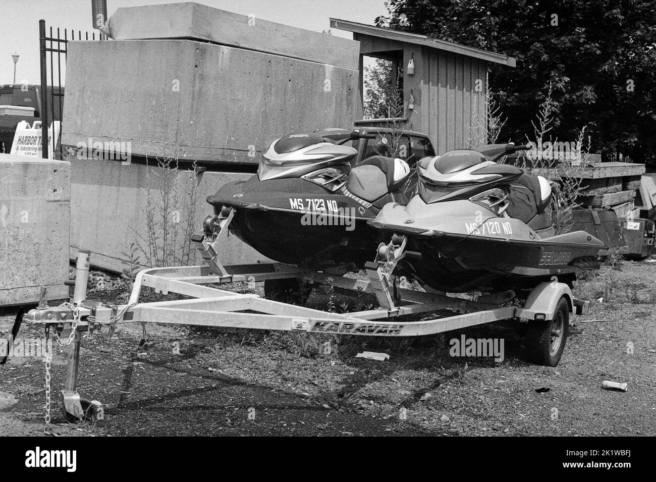 Jet Skis on a parked trailer in the parking lot of an abandoned factory ...