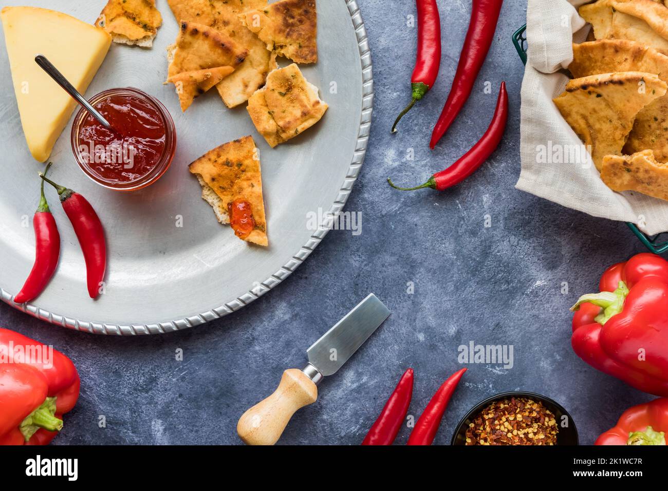 Top down view of hot pepper jelly in a jar served with crispy crackers ...