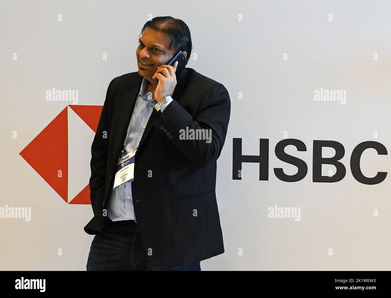 A man talks on the phone near the HSBC bank logo during the Global ...