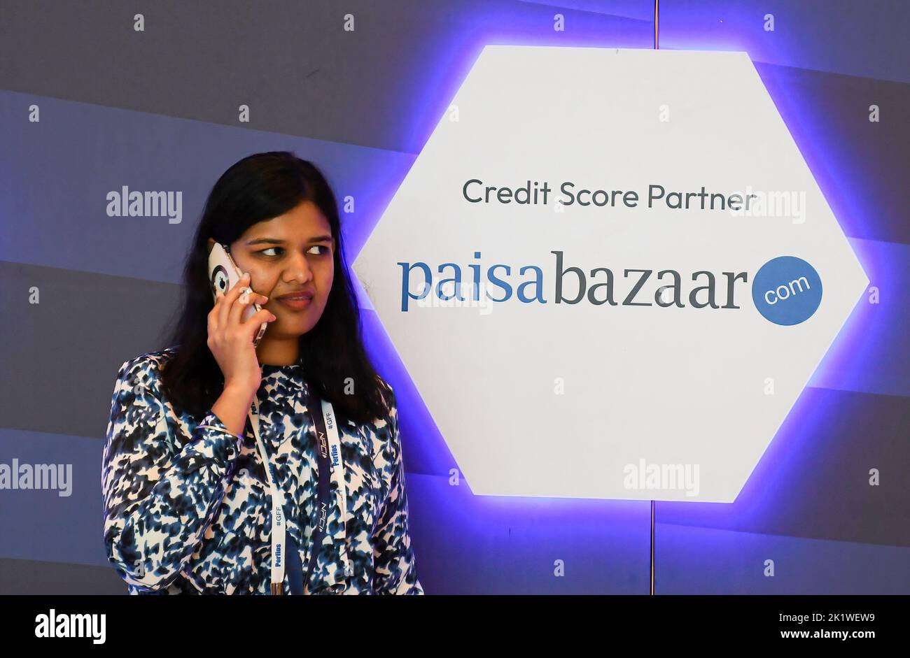 A woman talks on the phone near paisabazaar logo during the Global ...