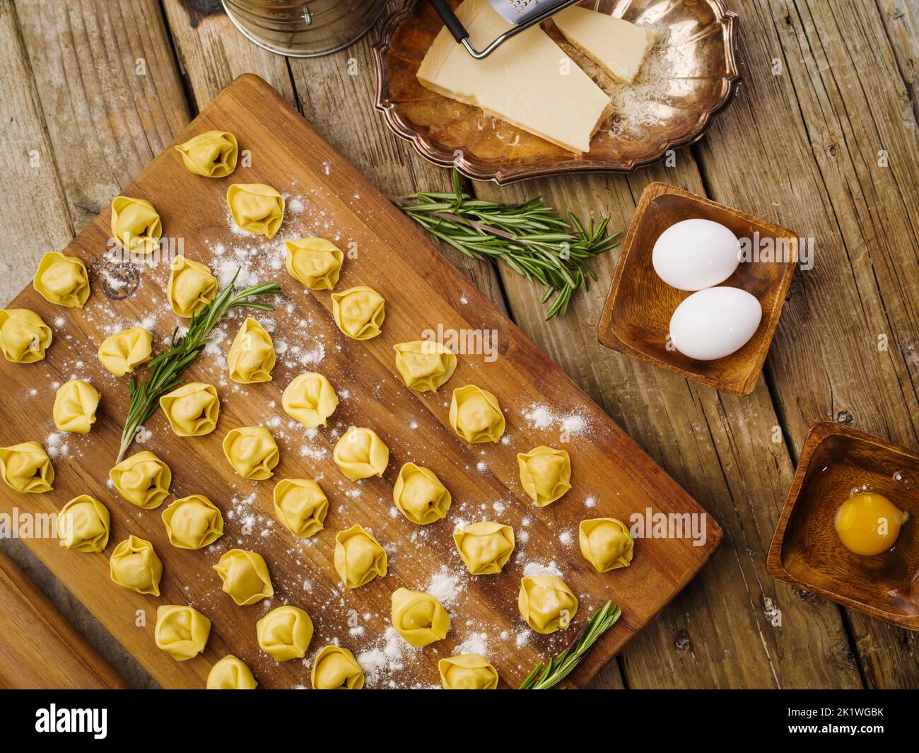 Raw homemade ravioli, dumplings on a wooden cutting board, ingredients ...