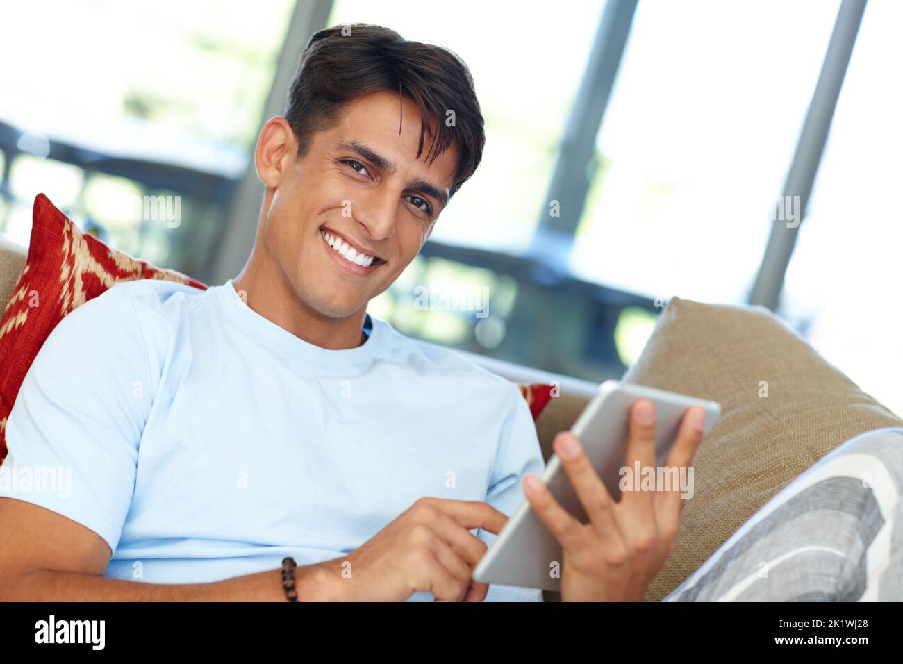 Technology just gets better. a young man using his digital tablet at ...