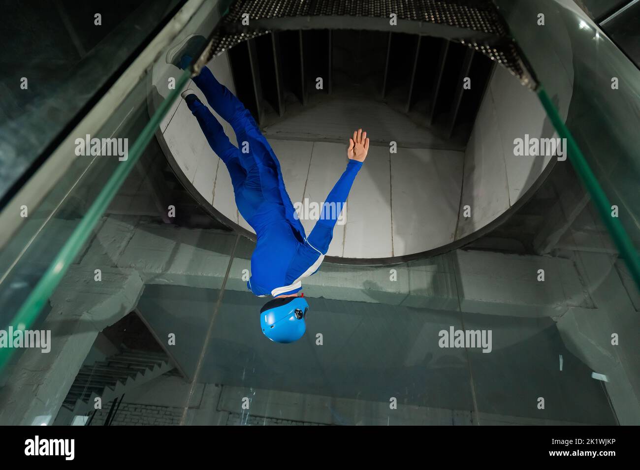 A man in overalls and a protective helmet enjoys flying in a wind ...