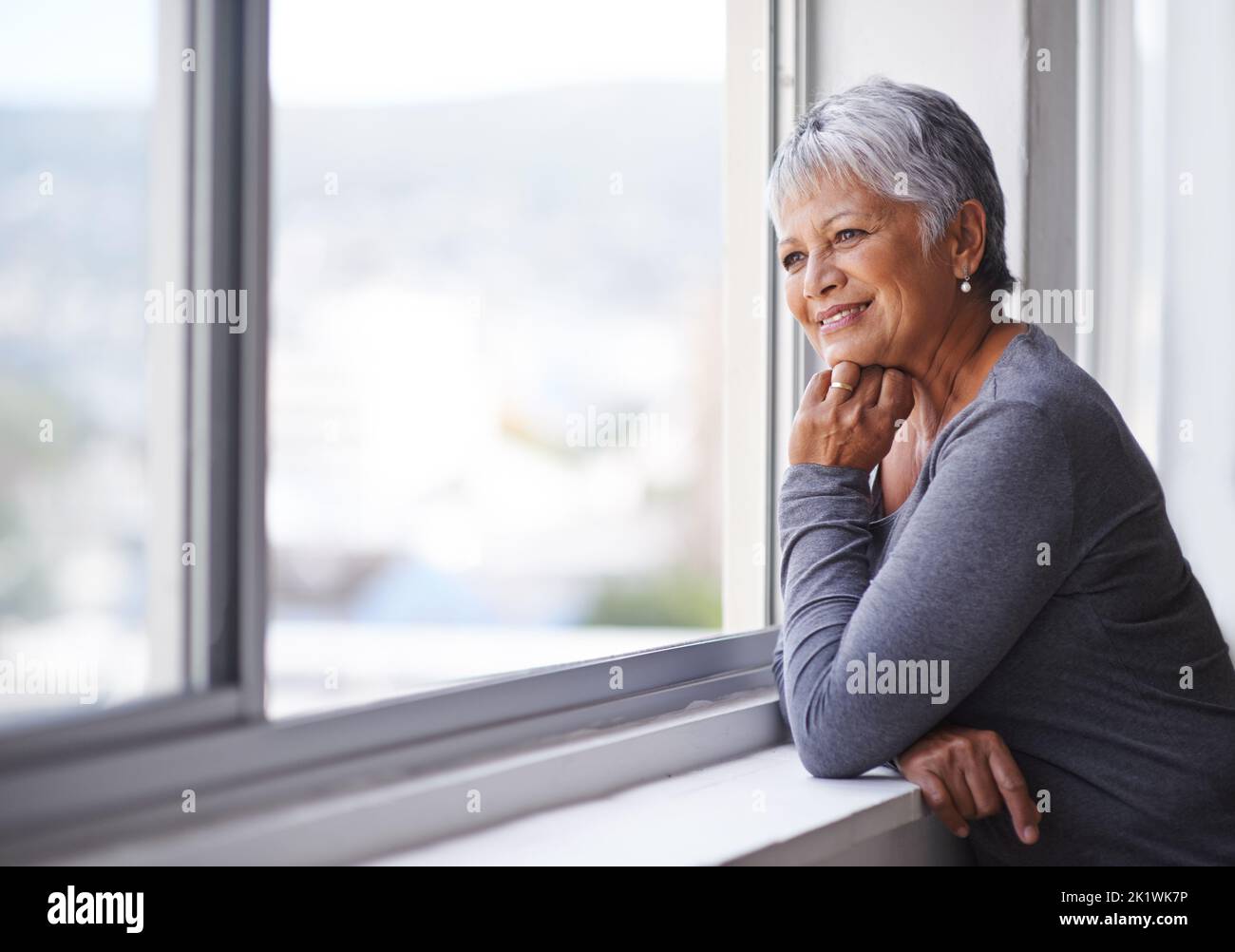 Happy mature woman by the window hi-res stock photography and images ...