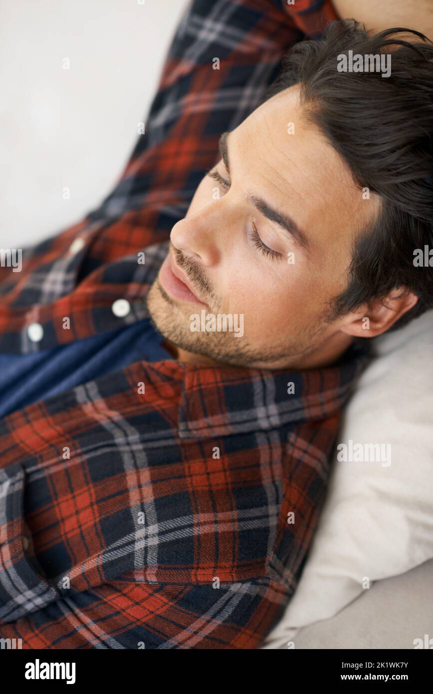Unwinding after a hectic day. A gorgeous young man lying down with his ...