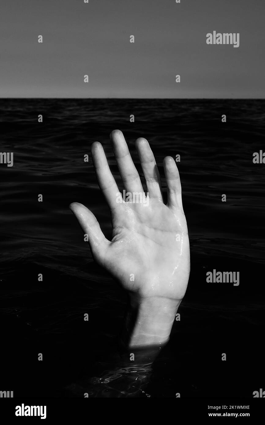 hand IN THE sea of a person who is drowning and seeks help with balck ...