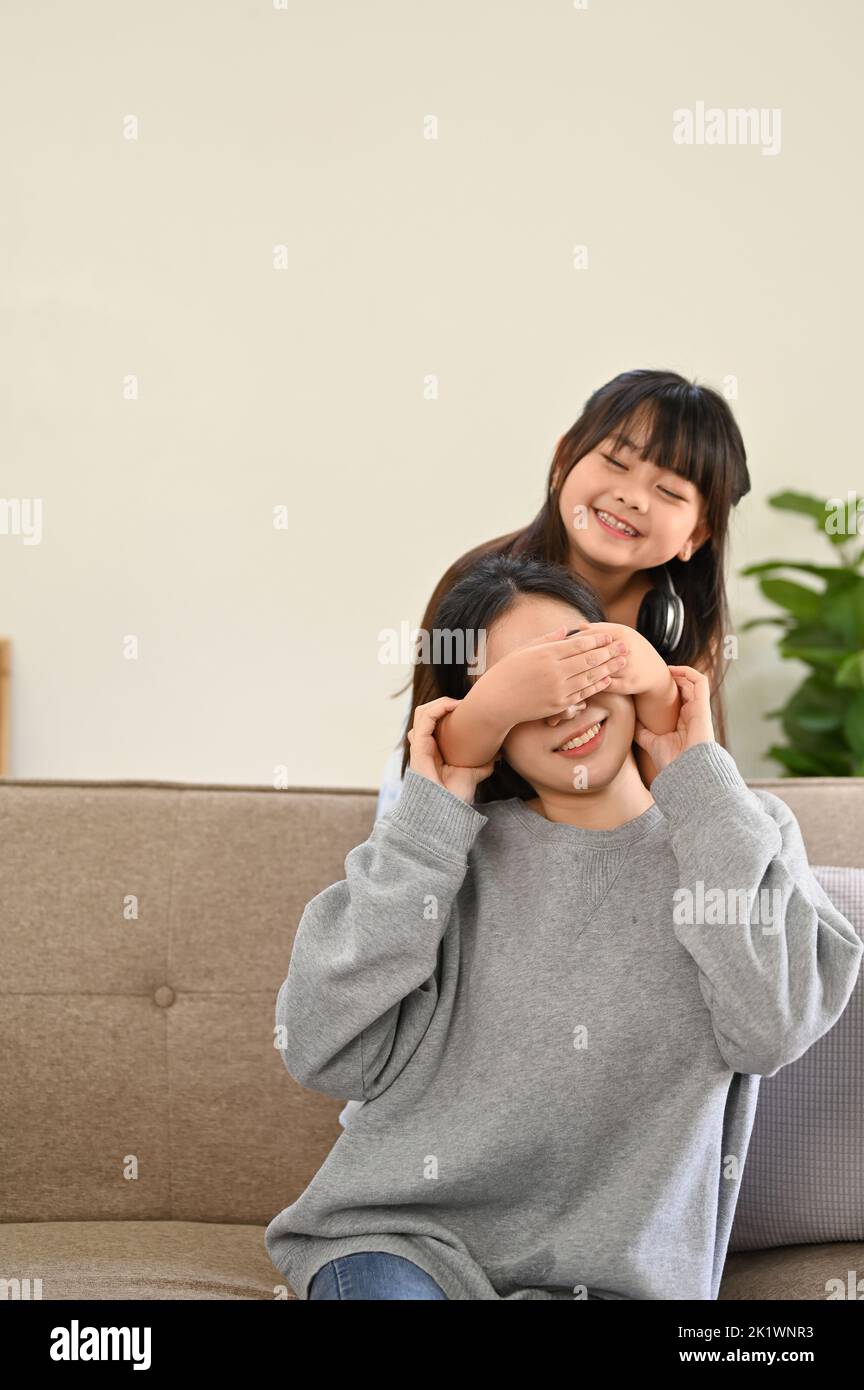 Portrait, Cute and playful young Asian girl surprising or playing peek ...