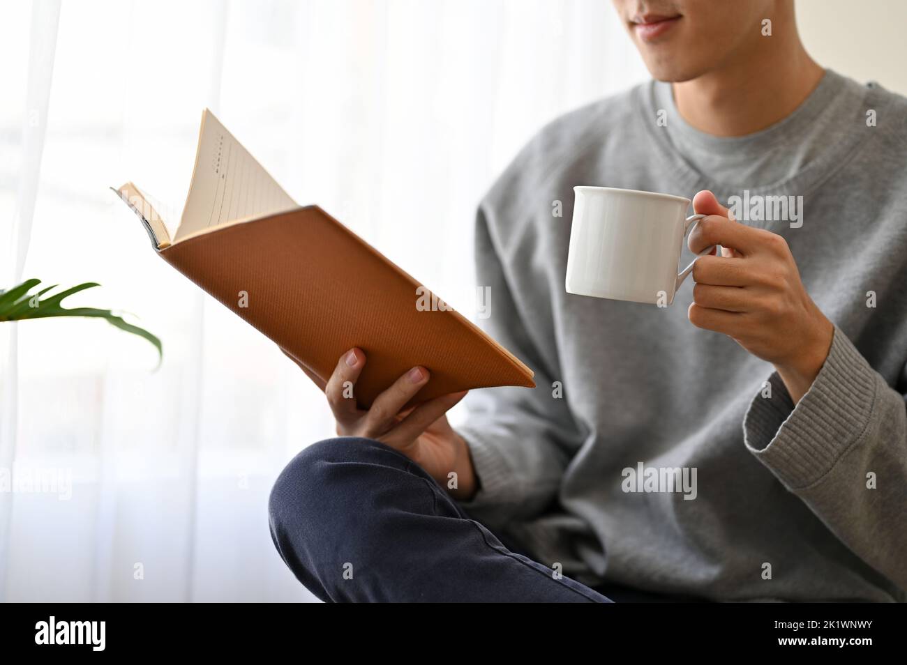 Relaxed and calm millennial Asian man spending his weekend at home ...