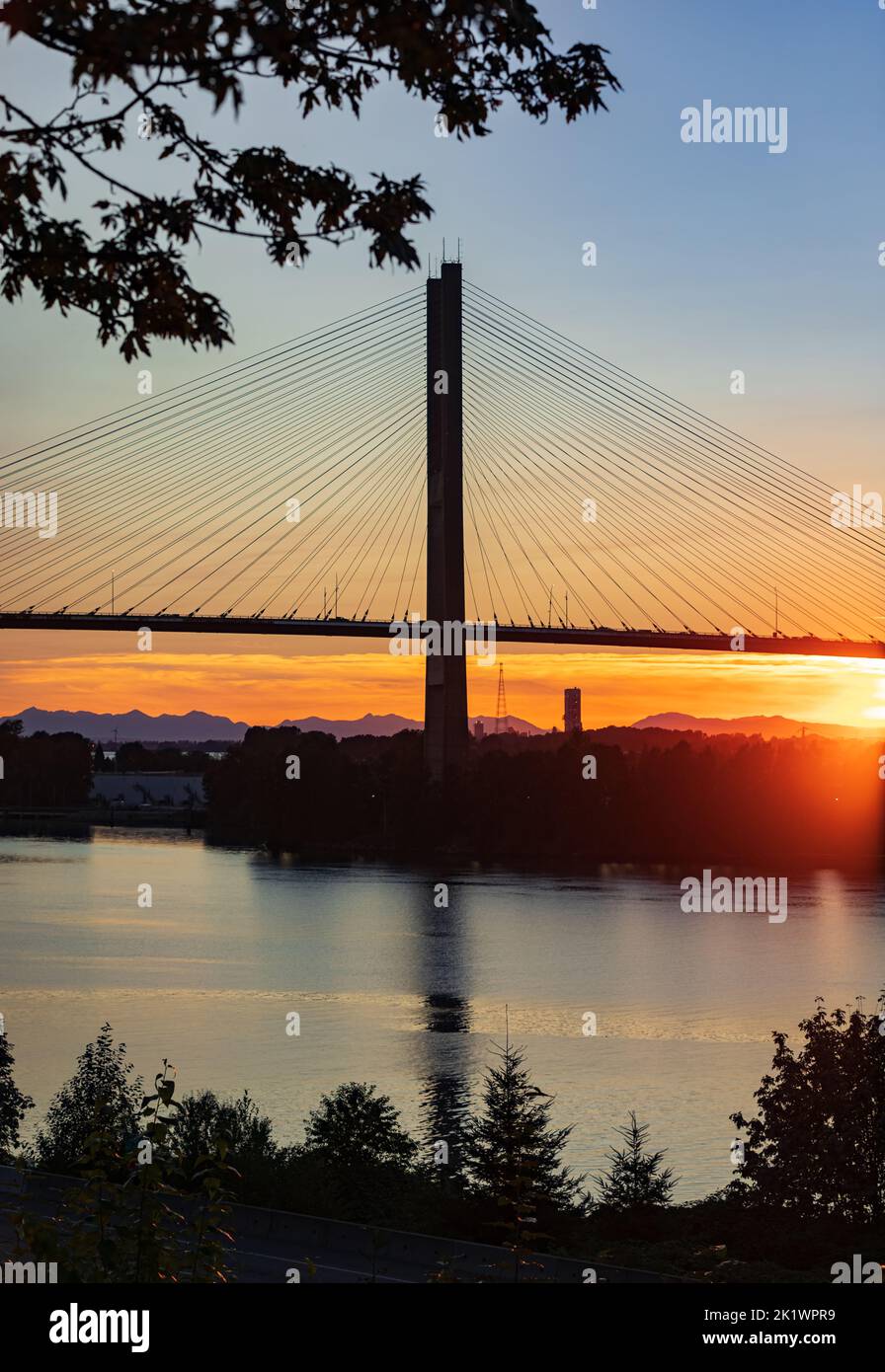 River and bridge at beautiful summer sunset. A view of the Alex Fraser ...