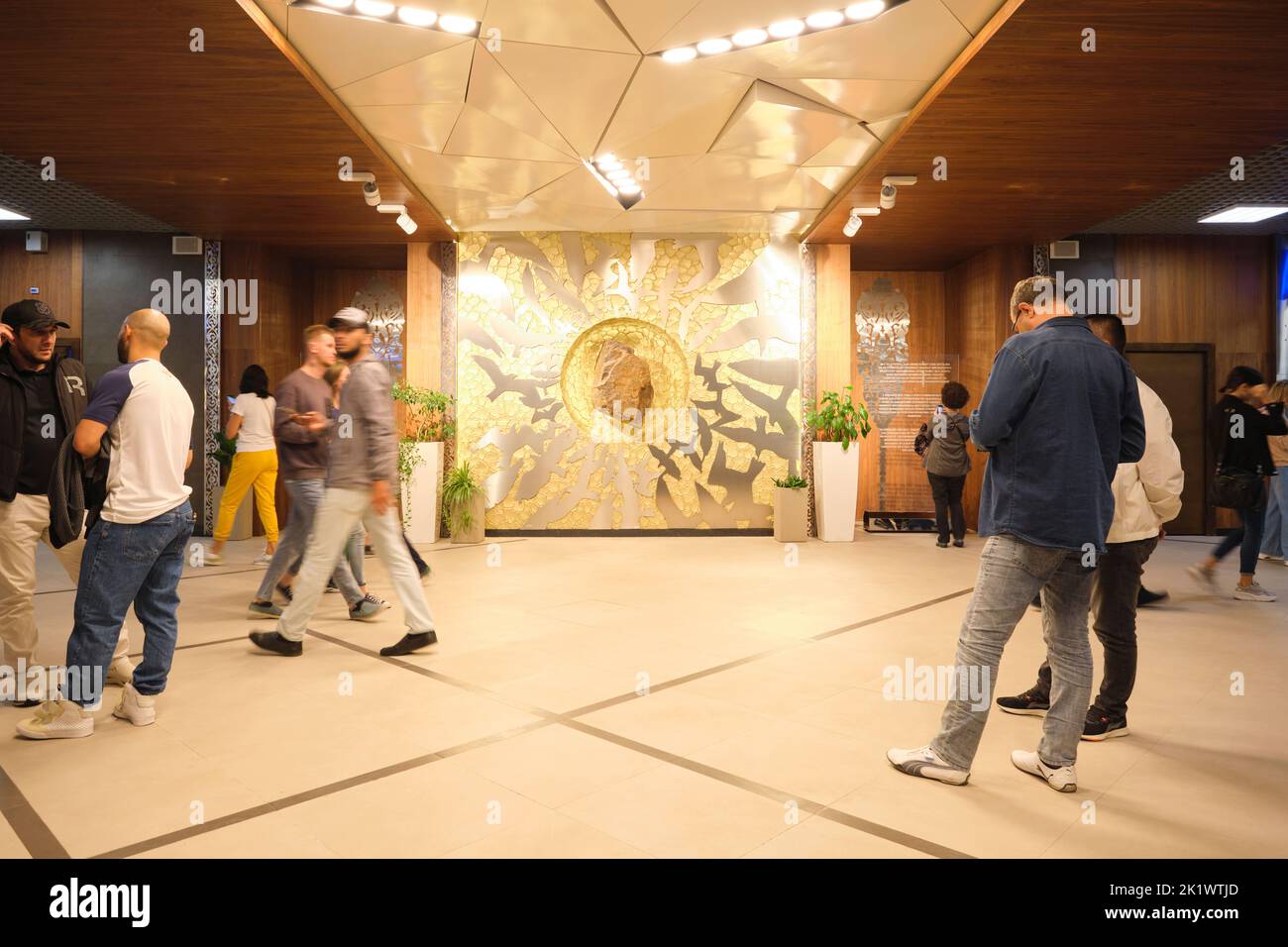 On the concourse, a wall artwork that incorporates a stone that ...