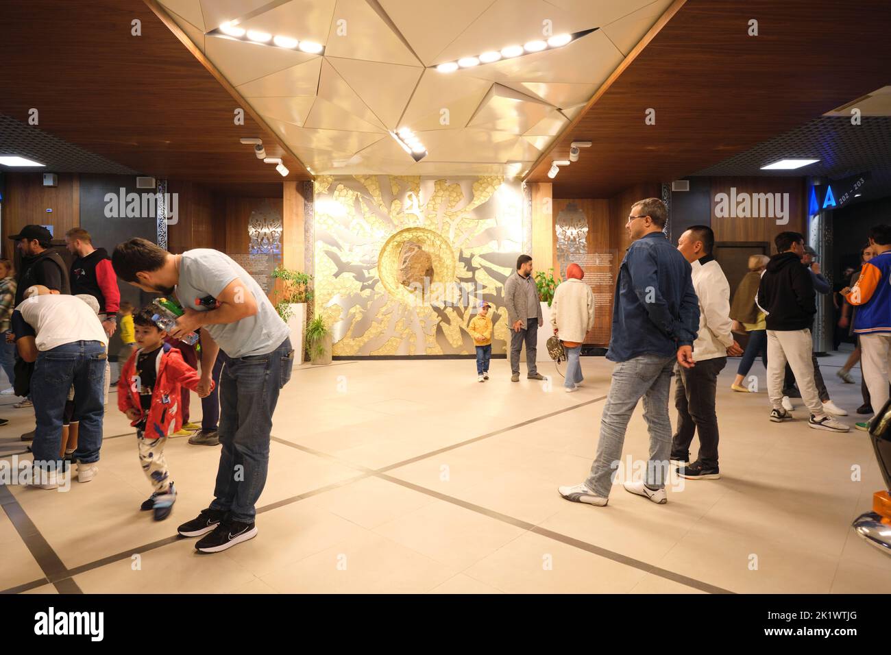 On the concourse, a wall artwork that incorporates a stone that ...