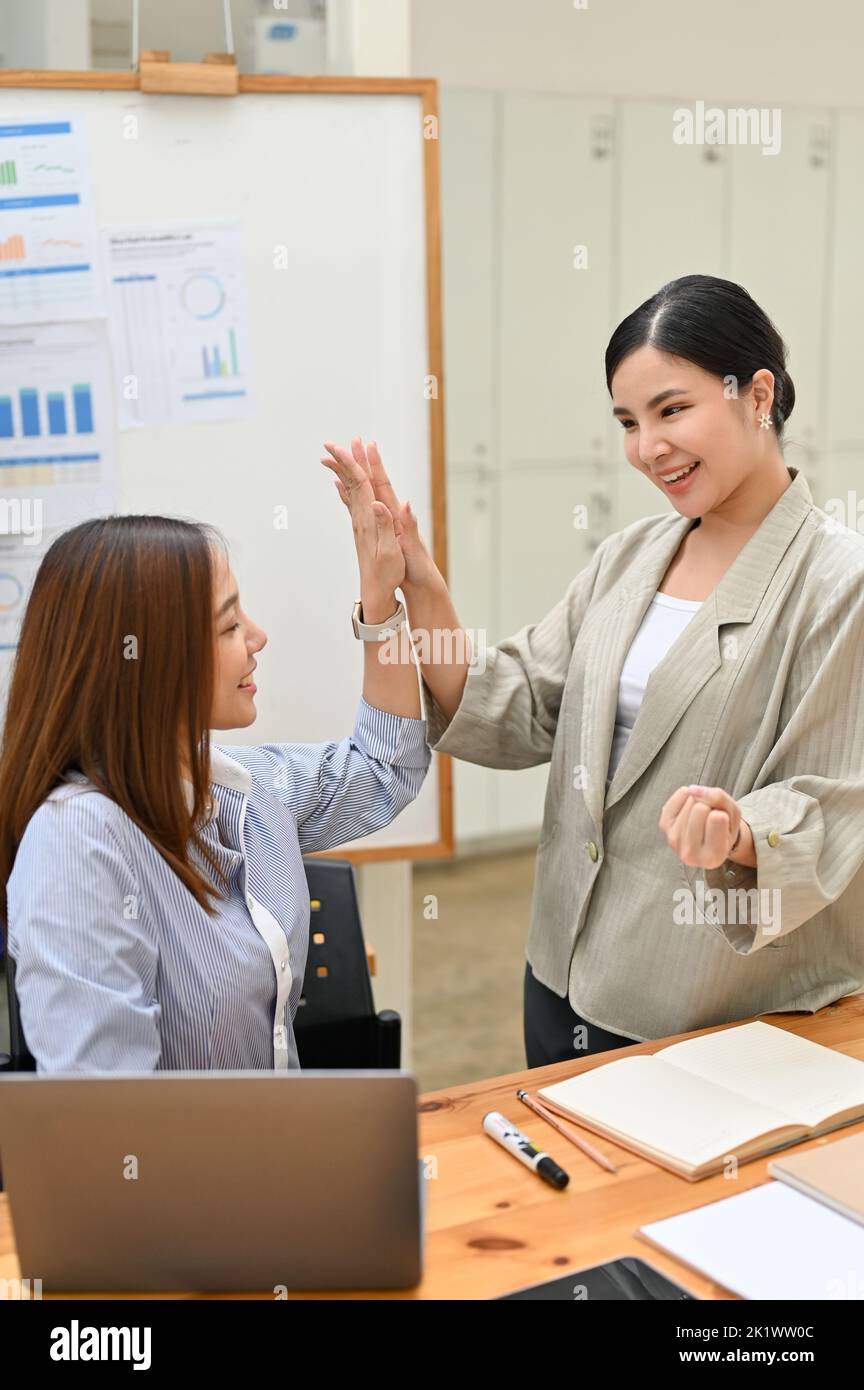 Portrait, Beautiful and happy millennial Asian businesswomen or female office worker celebrate ...