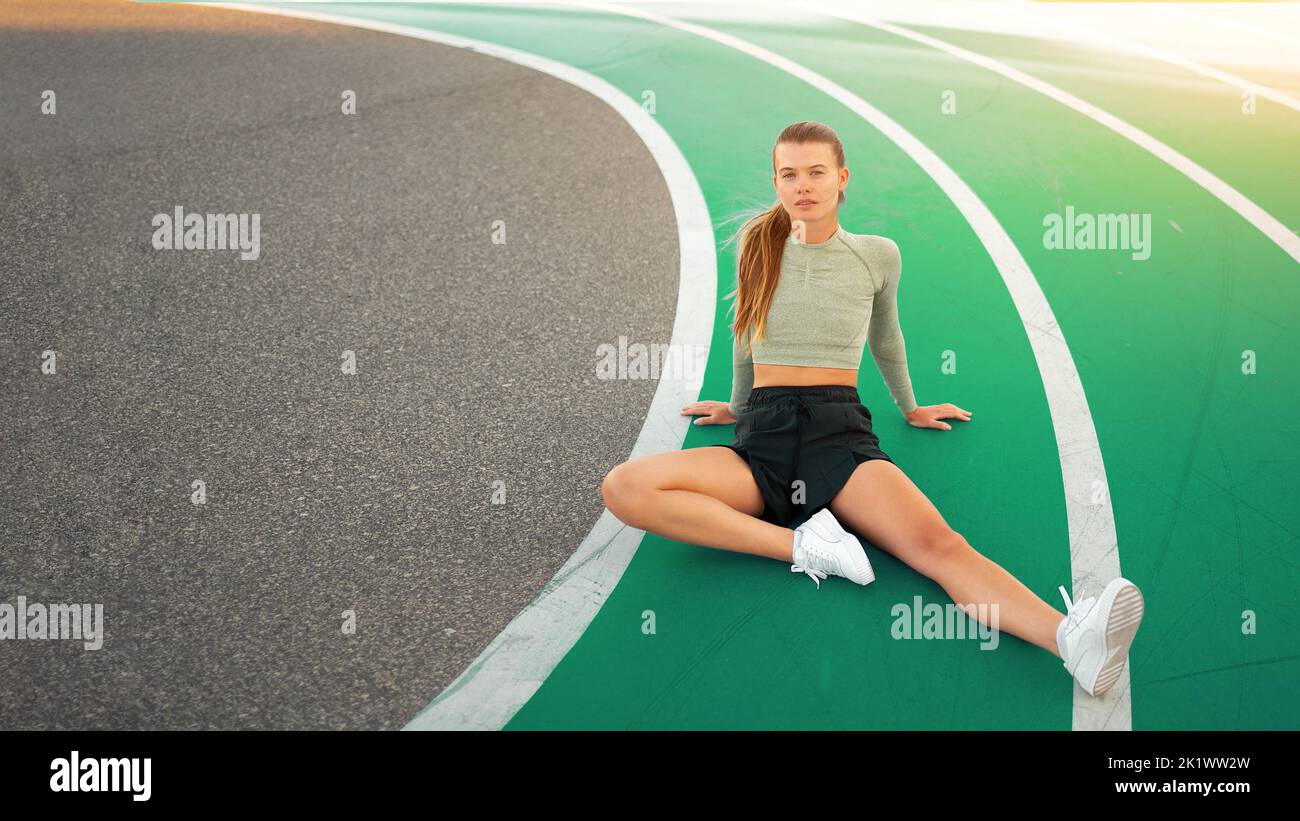 Tired happy woman runner taking rest after run sitting on the running ...