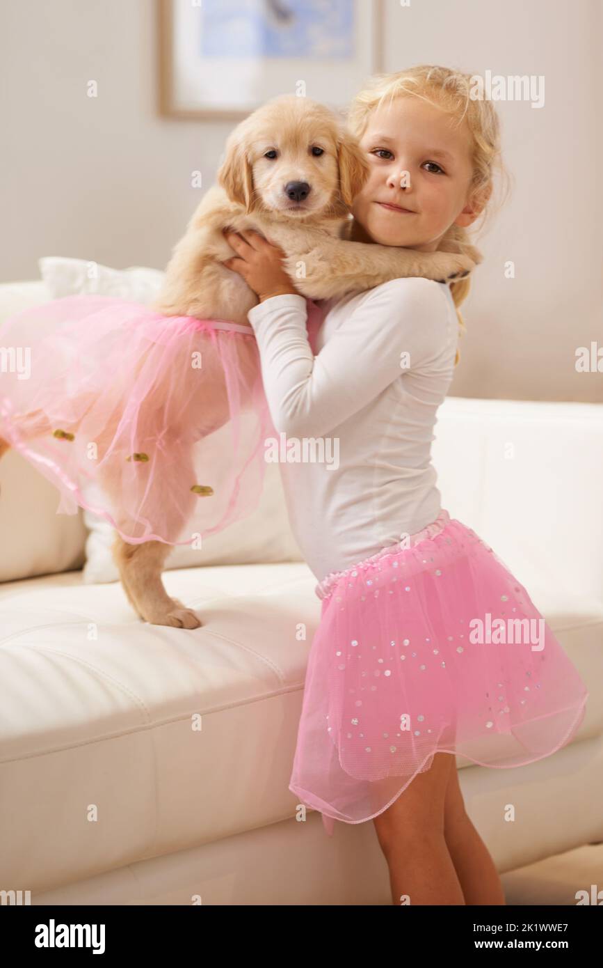 Dont we look like twins. A little girl dressing her puppy in a tutu ...