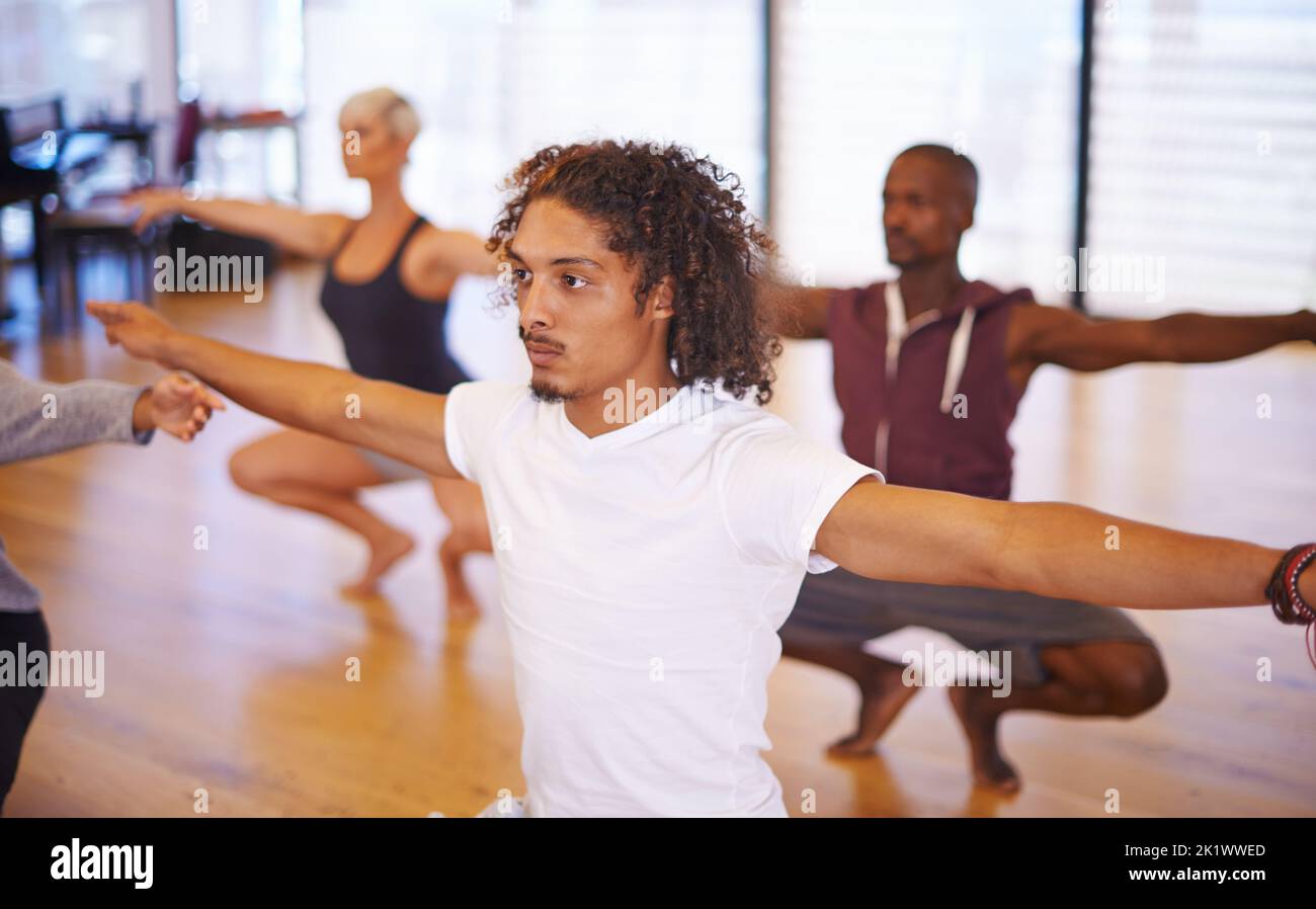 Keeping fit and flexible. a group of young dancers squatting in a dance ...