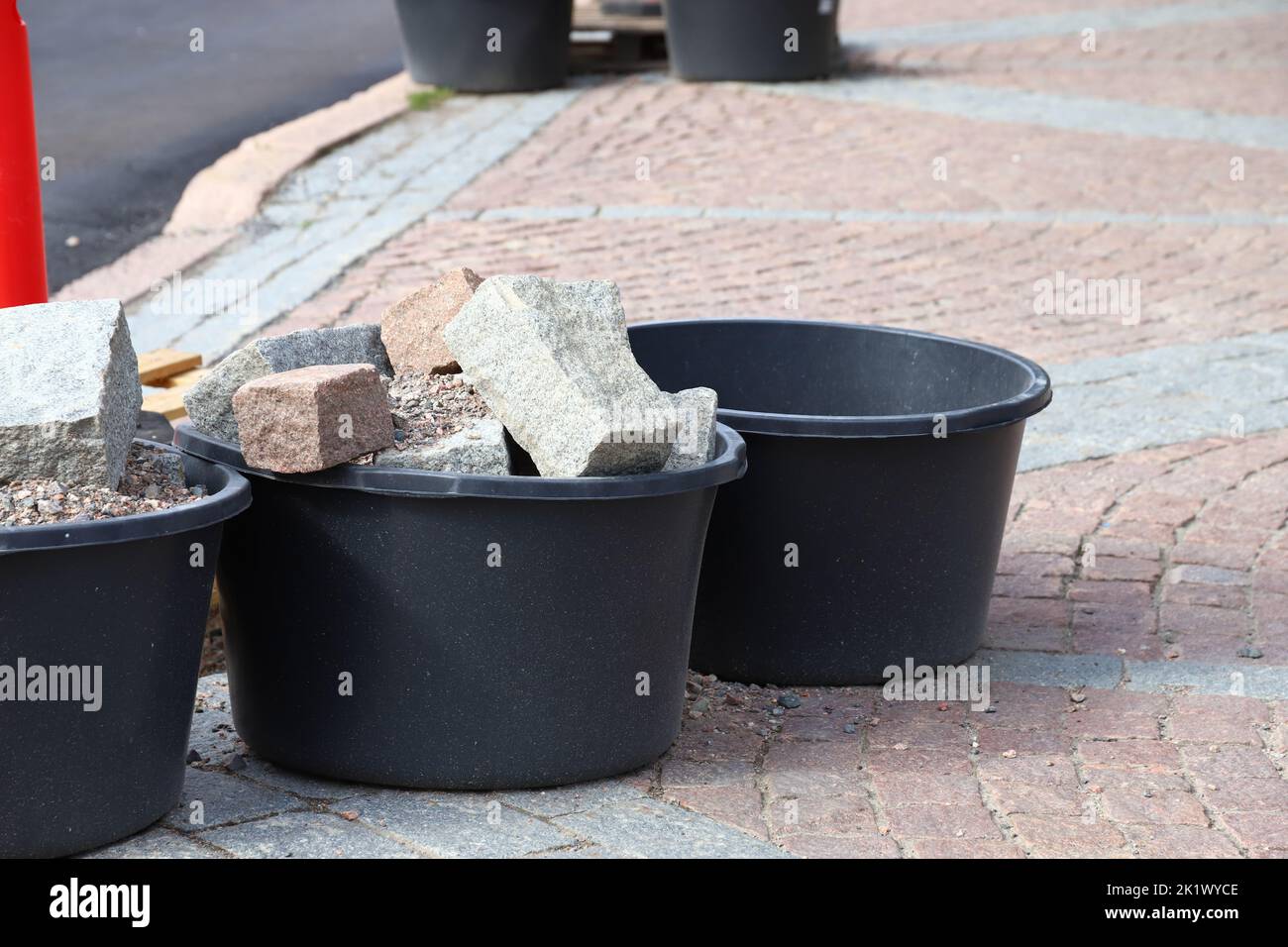 A brick on a black container Stock Photo - Alamy