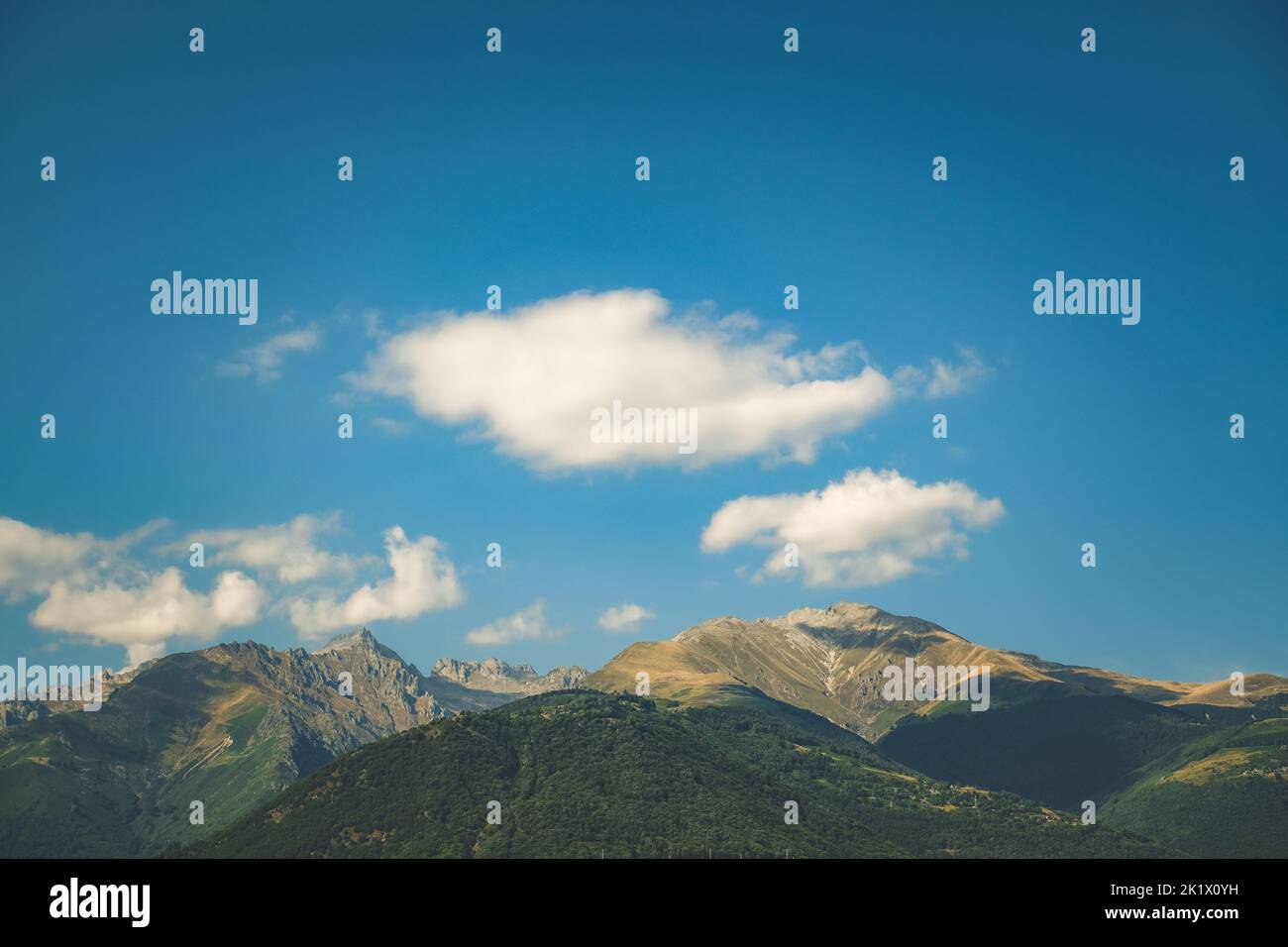 A low-angle shot of green mountains with the sky in the background and ...