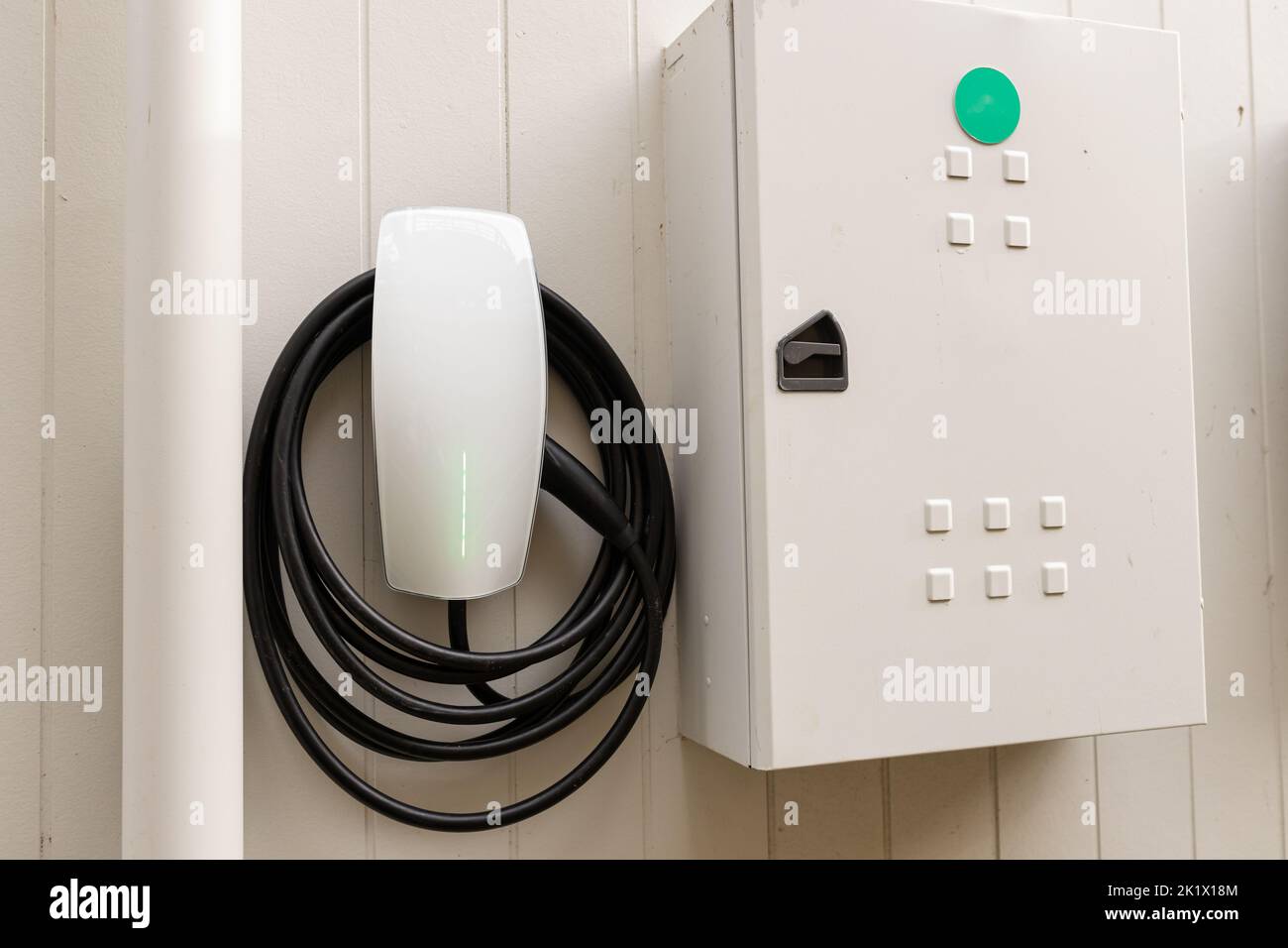 An electric vehicle car charger on the wall of a house with the switch ...