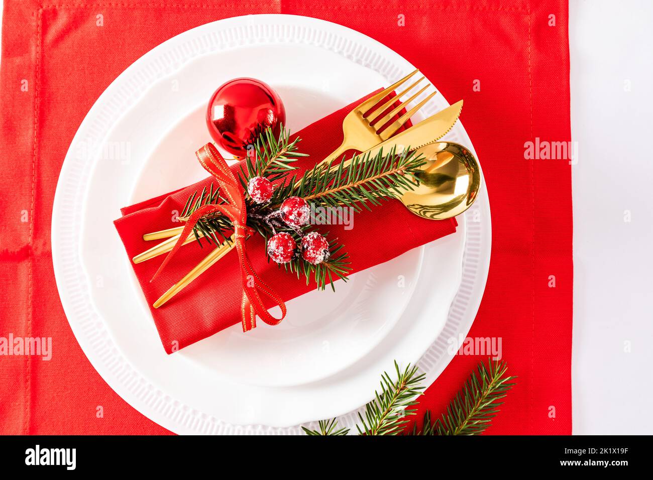 Serving a Christmas table with a set of white plates, gold table surfs ...