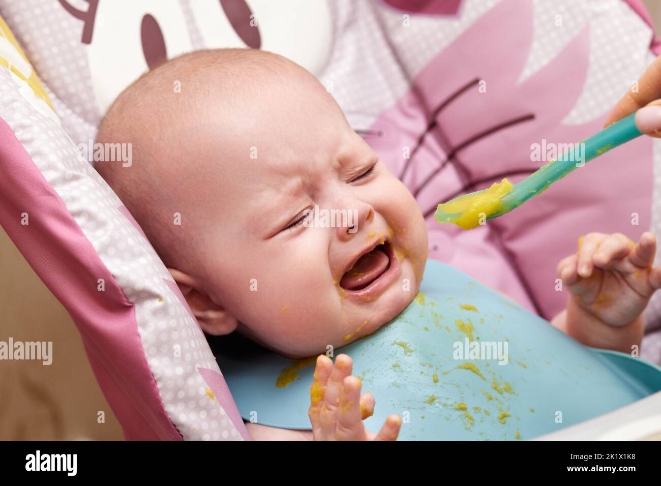 baby girl eating with spoon in kitchen Stock Photo - Alamy