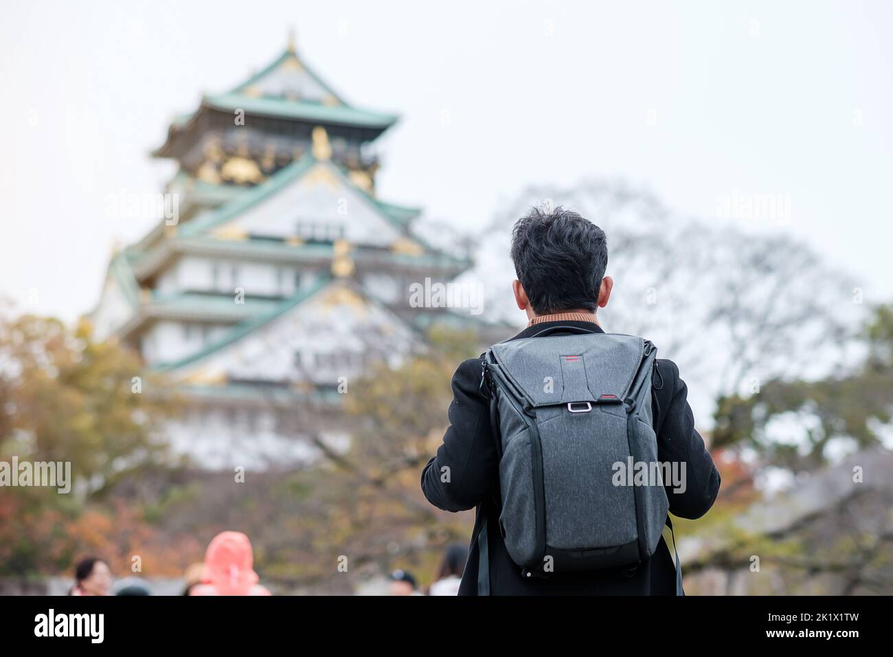 solo man tourist trveling at Osaka castle in Autumn season, Asian ...