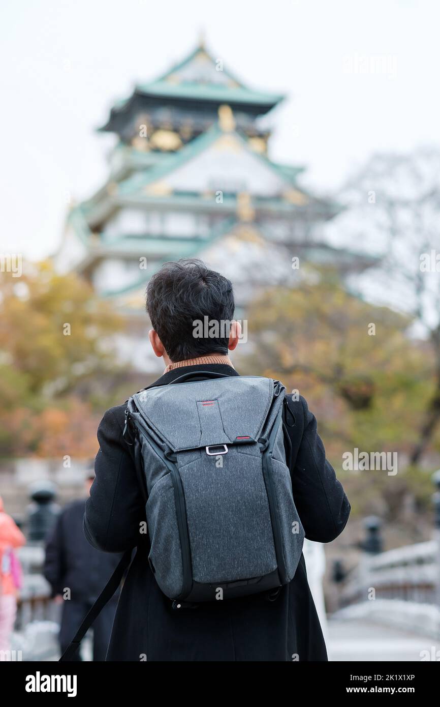 solo man tourist trveling at Osaka castle in Autumn season, Asian ...