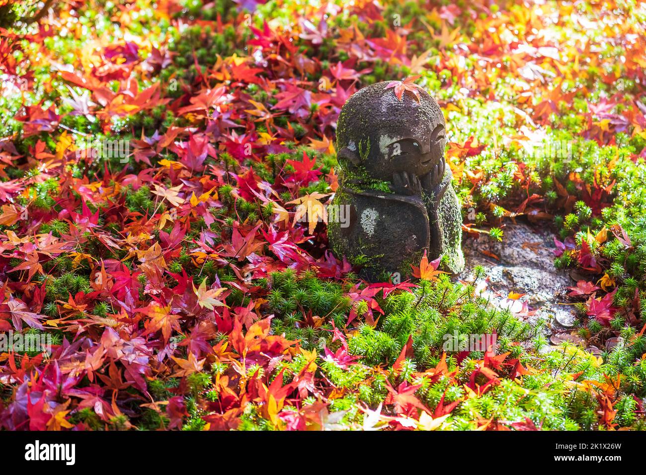 Japanese Jizo sculpture doll with falling Red Maple leaf in Japanese ...