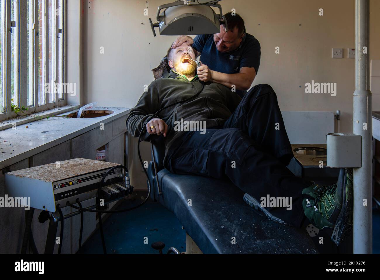 A man has dental work in an abandoned dentist surgery with old, rusty ...